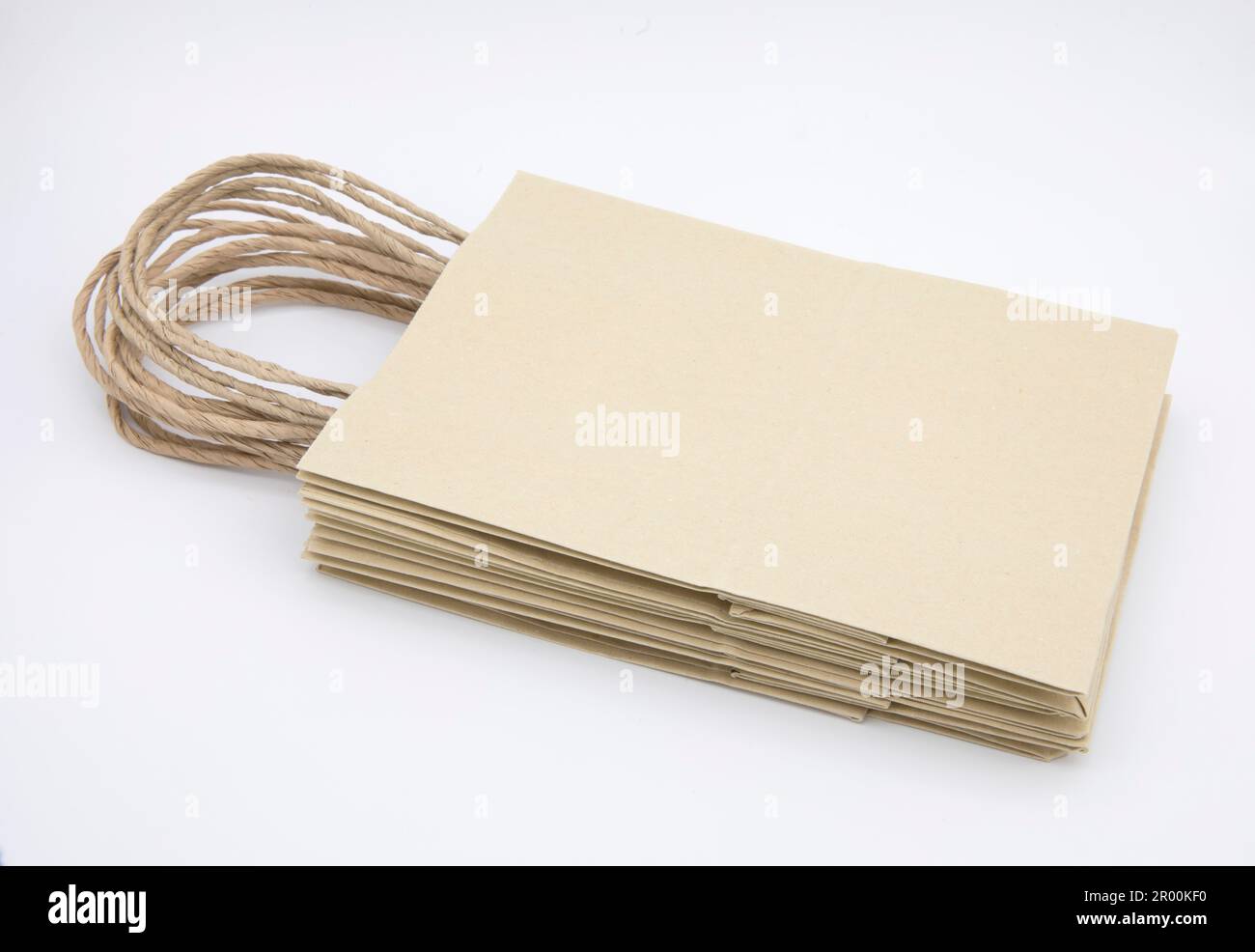 Pile of beige paper bags isolated on white background Stock Photo - Alamy