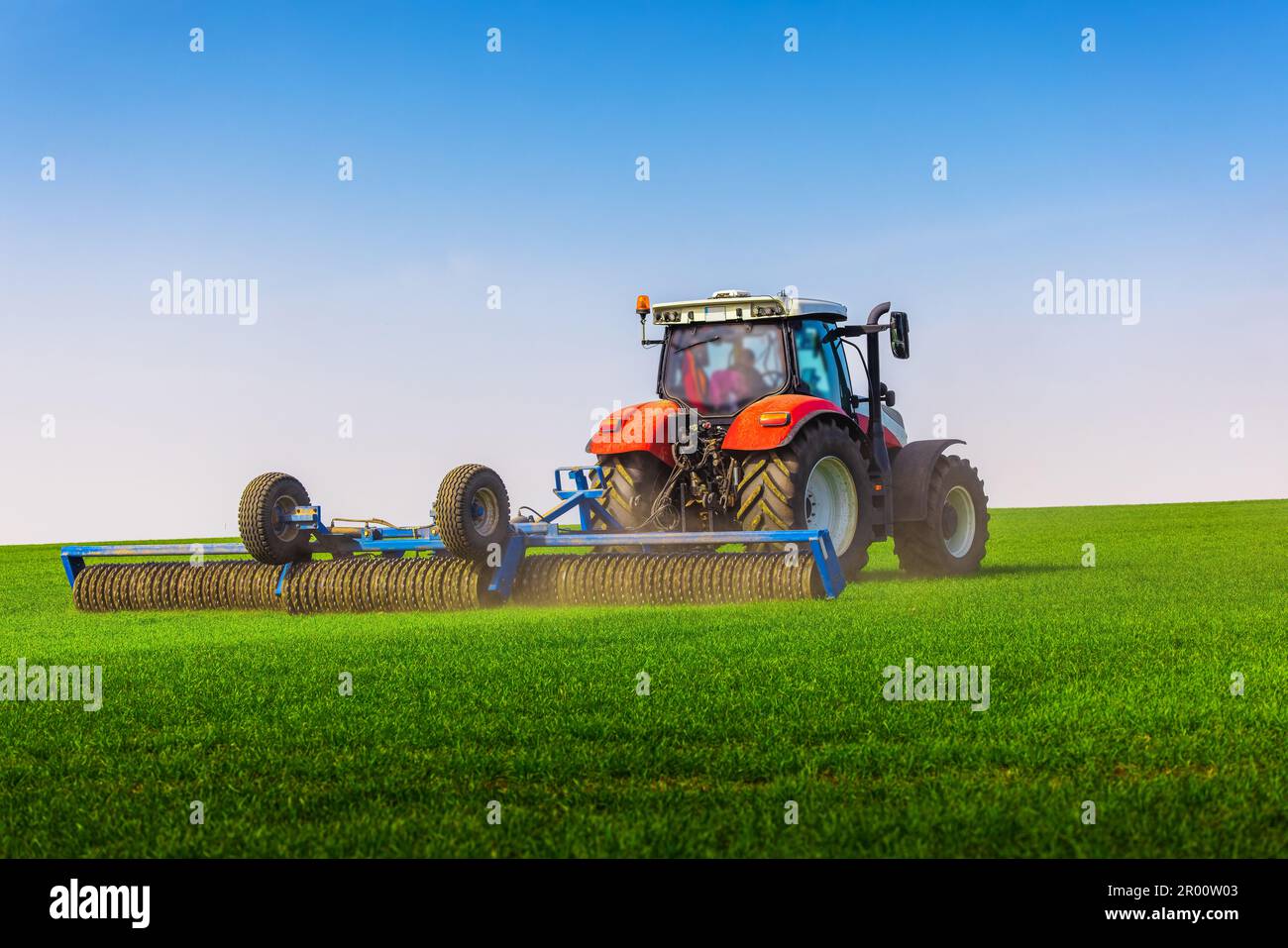 Tractor with a roller tillage on spring field. Soil rolling supports ...