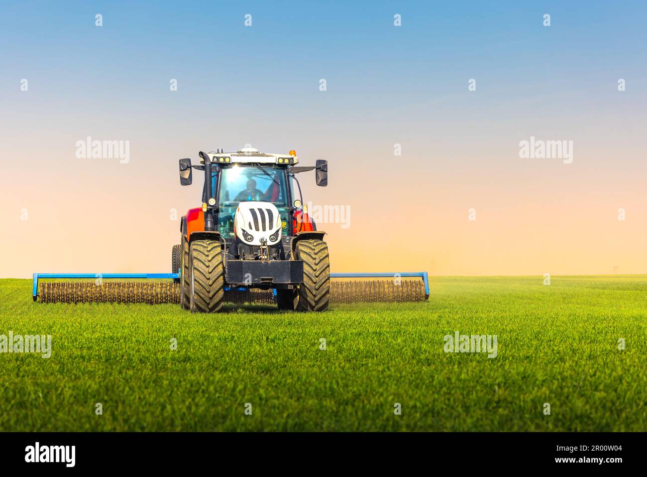 Tractor with a roller tillage on spring field. Soil rolling supports ...