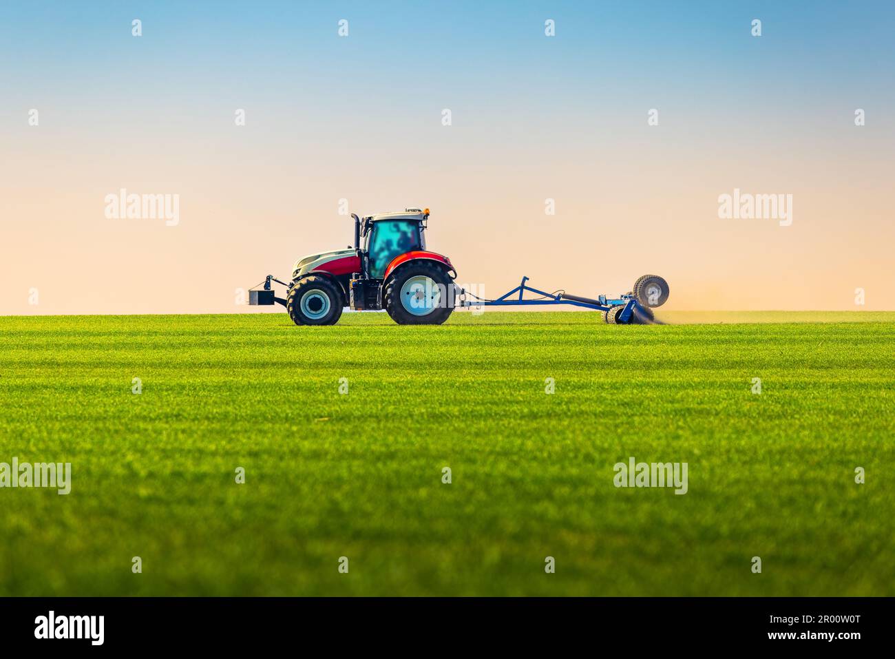 Tractor with a roller tillage on spring field. Soil rolling supports ...