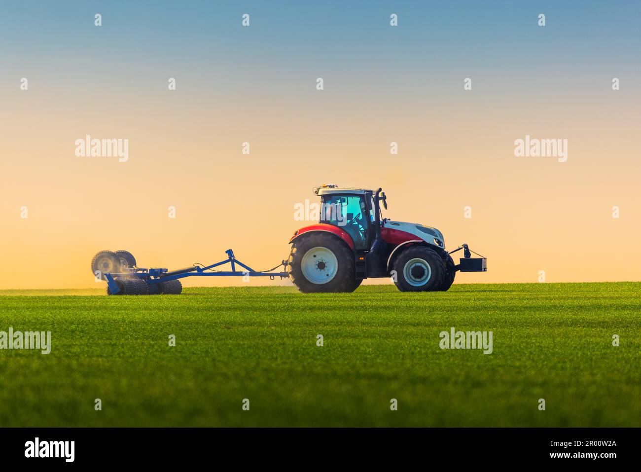 Tractor with a roller tillage on spring field. Soil rolling supports ...