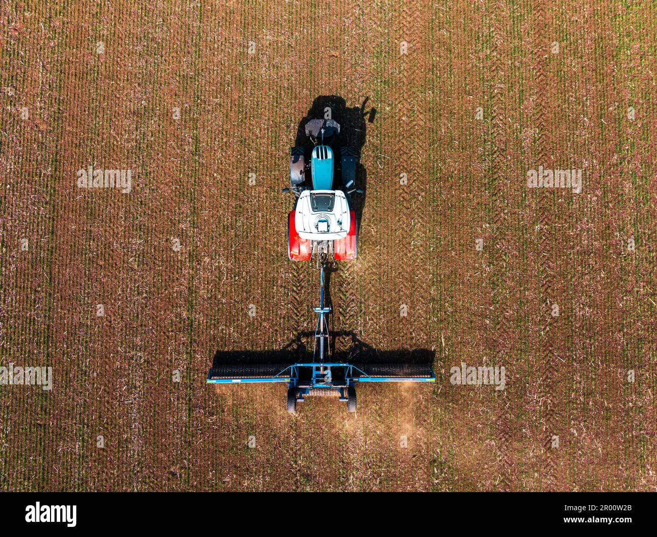 Tractor with a roller tillage on spring field. Aerial view of Soil ...