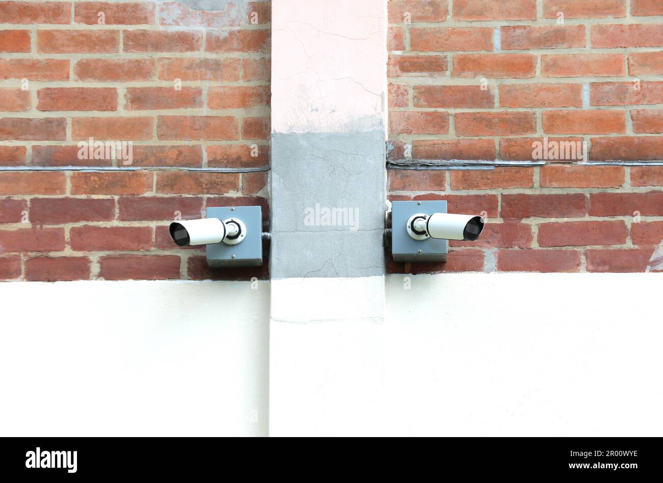 Two surveillance cameras installed on red brick wall Stock Photo - Alamy