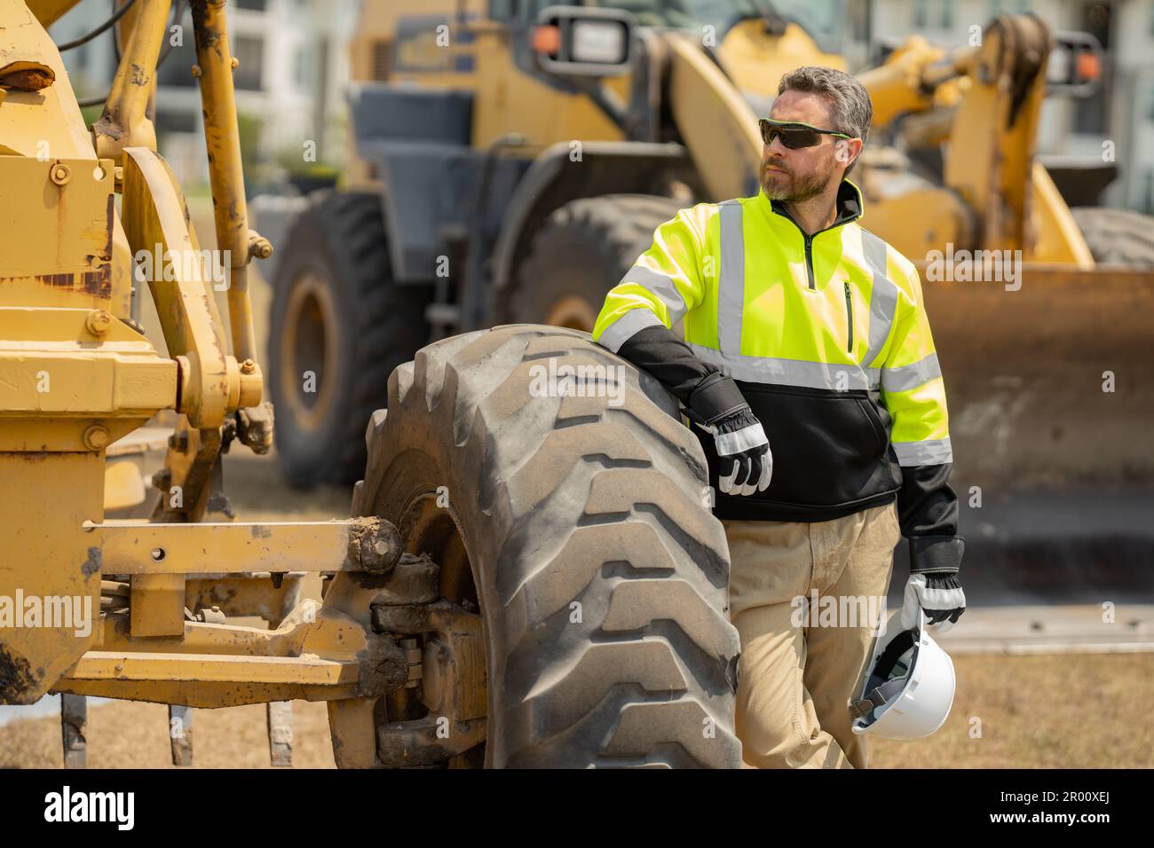 Portrait of builder in a construction site. Builder with excavator ...