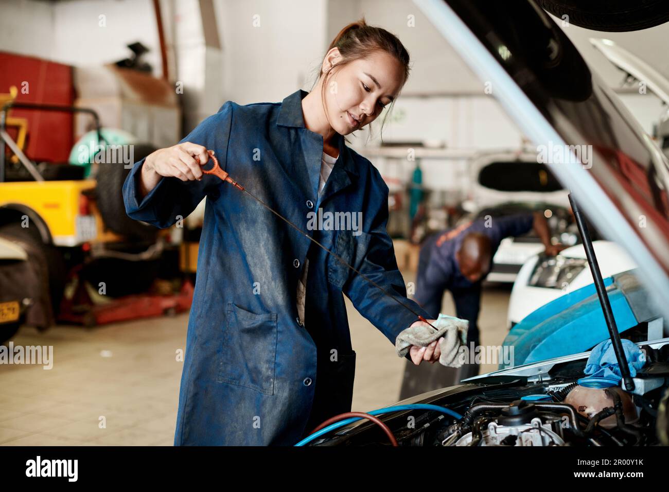 Get your oil changed regularly. a female mechanic holding a dipstick ...