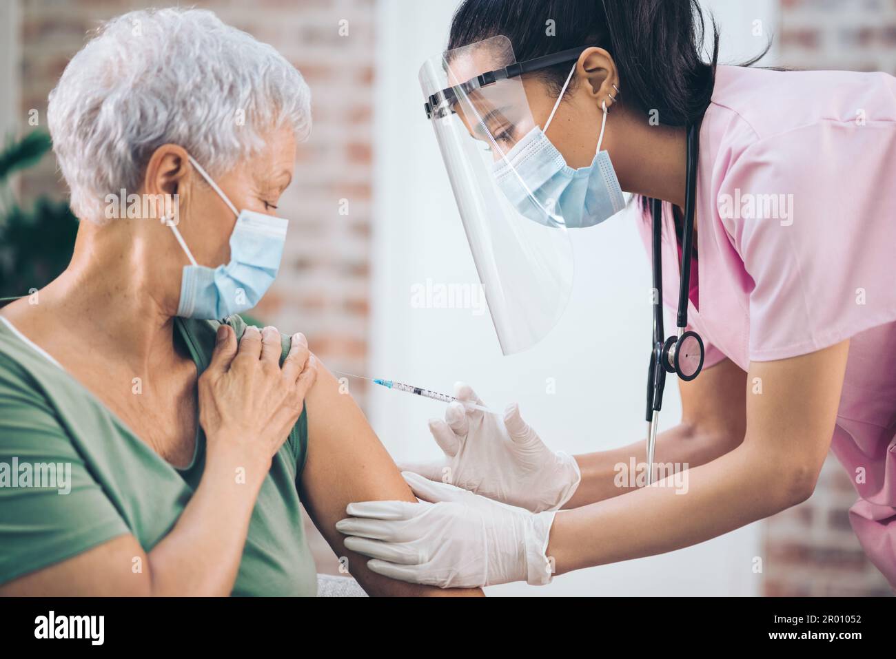 Yes, itll hurt. a doctor giving a masked older woman an injection at ...