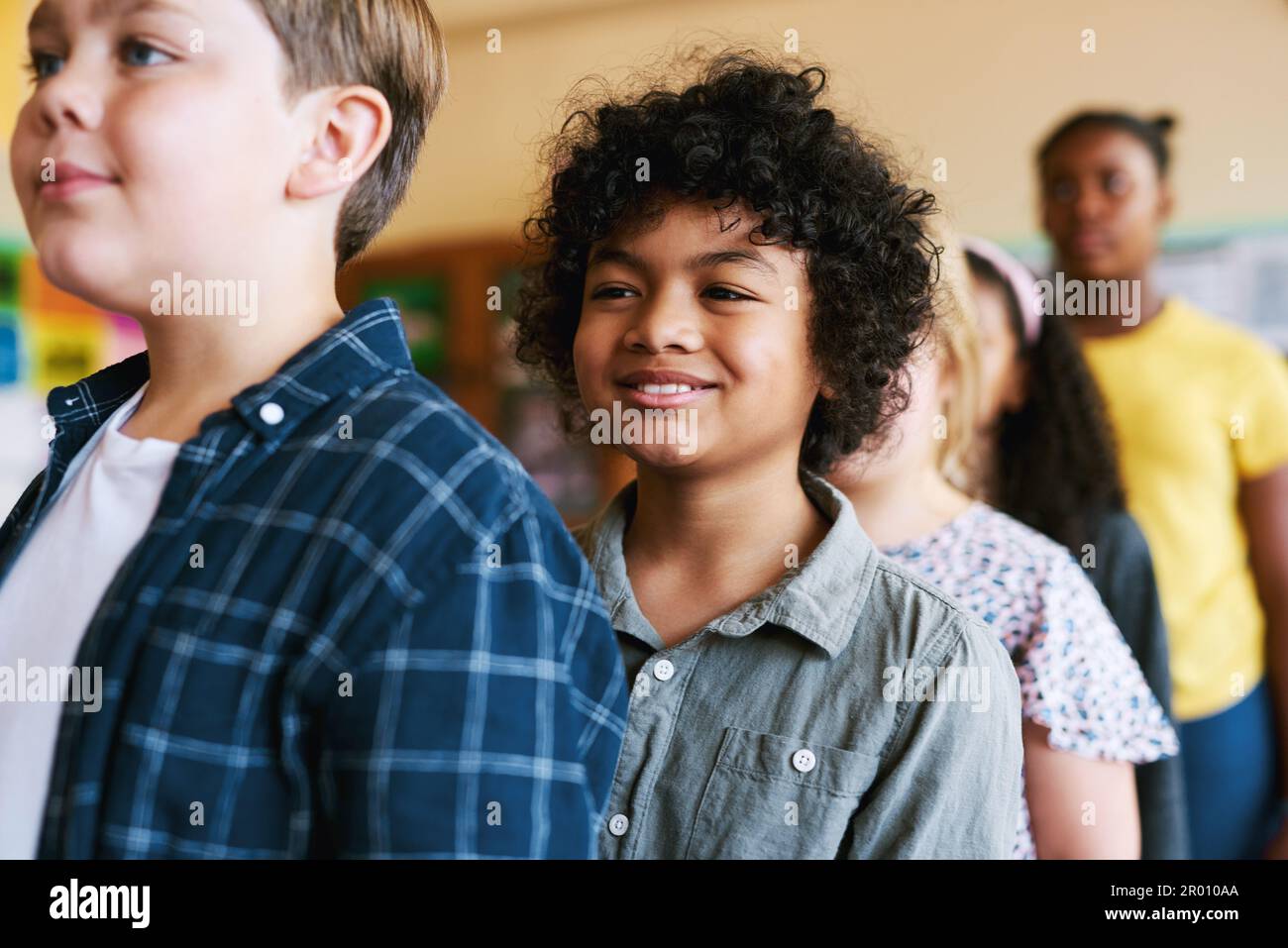 Lining up for a routine checkup. a diverse group of children standing ...