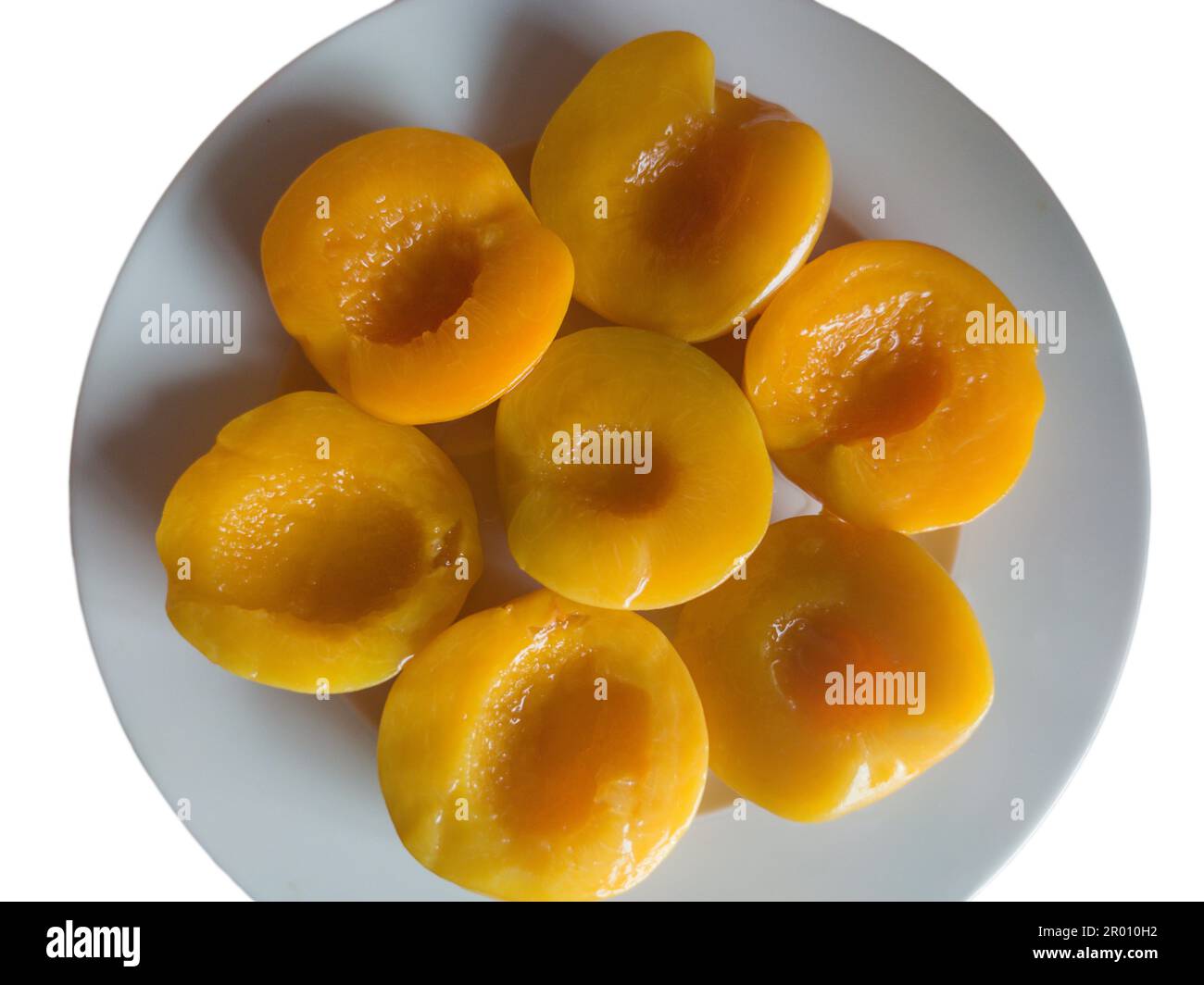 Plate of peaches halves in syrup. Isolated over white Stock Photo - Alamy