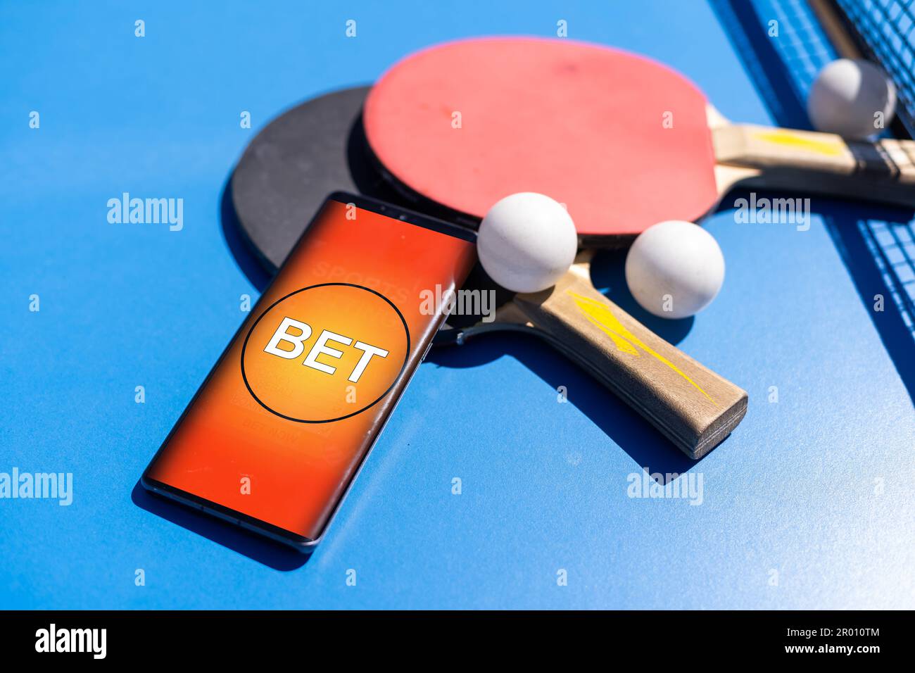 Smartphone on a blue table with ping pong rackets, rope and on ...