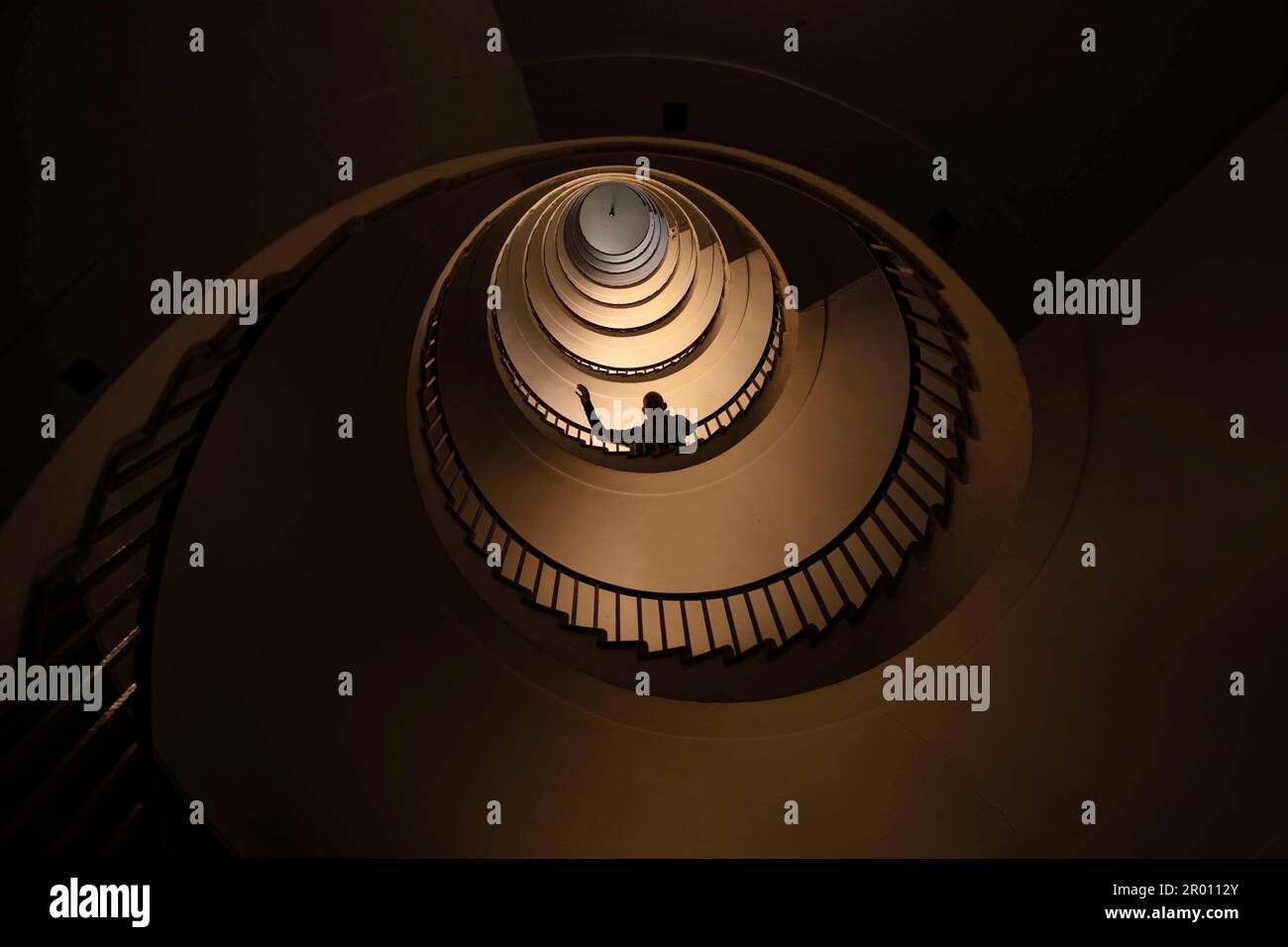 Spiral staircase in a tall multi-floor house, in the form of a "golden ...