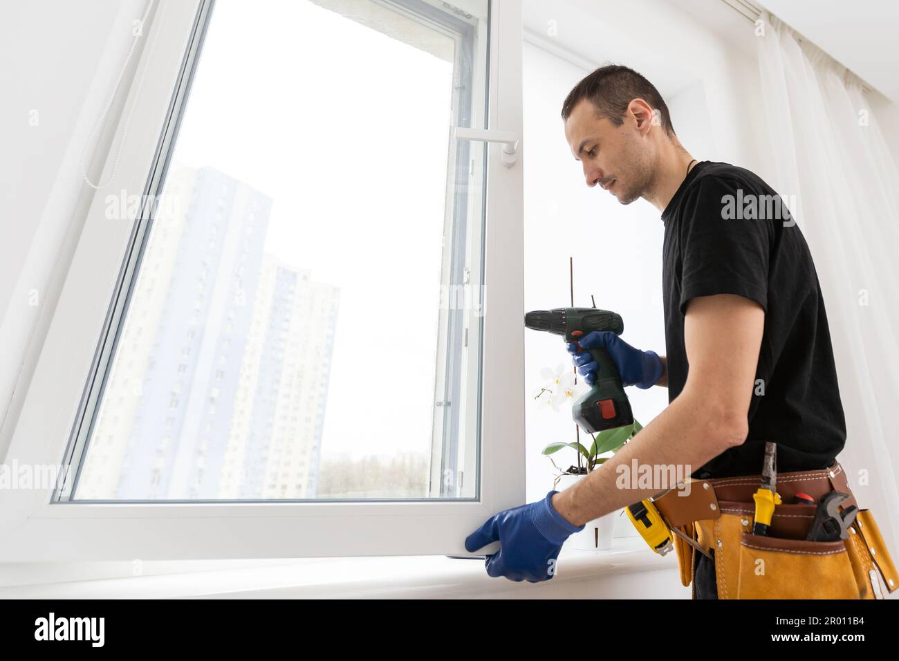 Worker adjusting installed window with screwdriver indoors, closeup ...