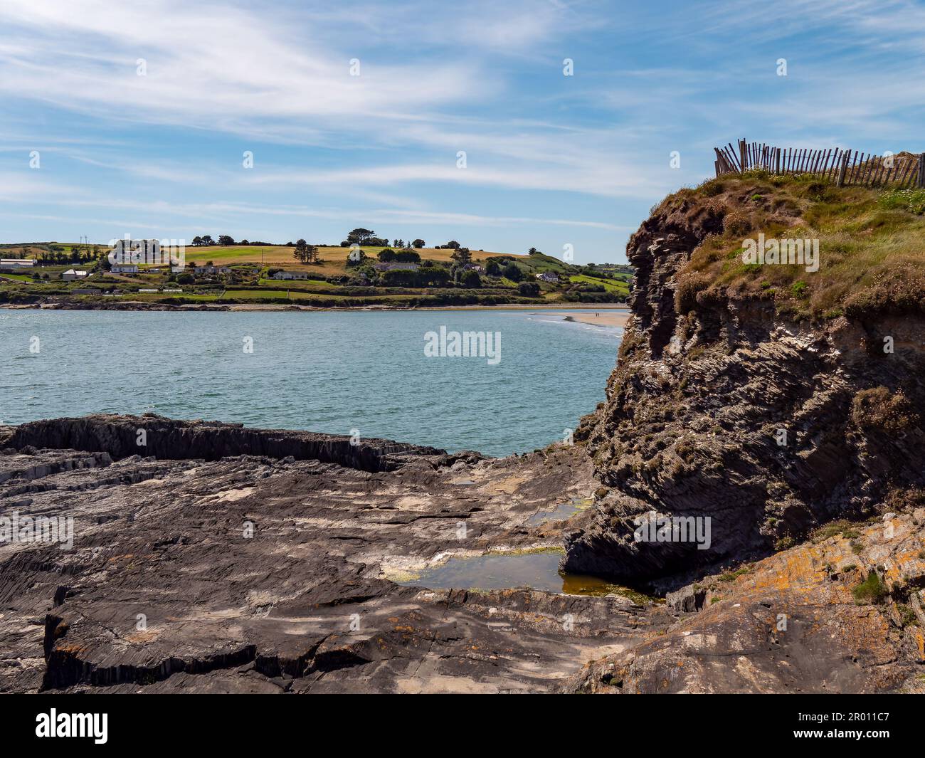 A sheer stone cliff on the Atlantic Ocean in Ireland on a sunny summer ...