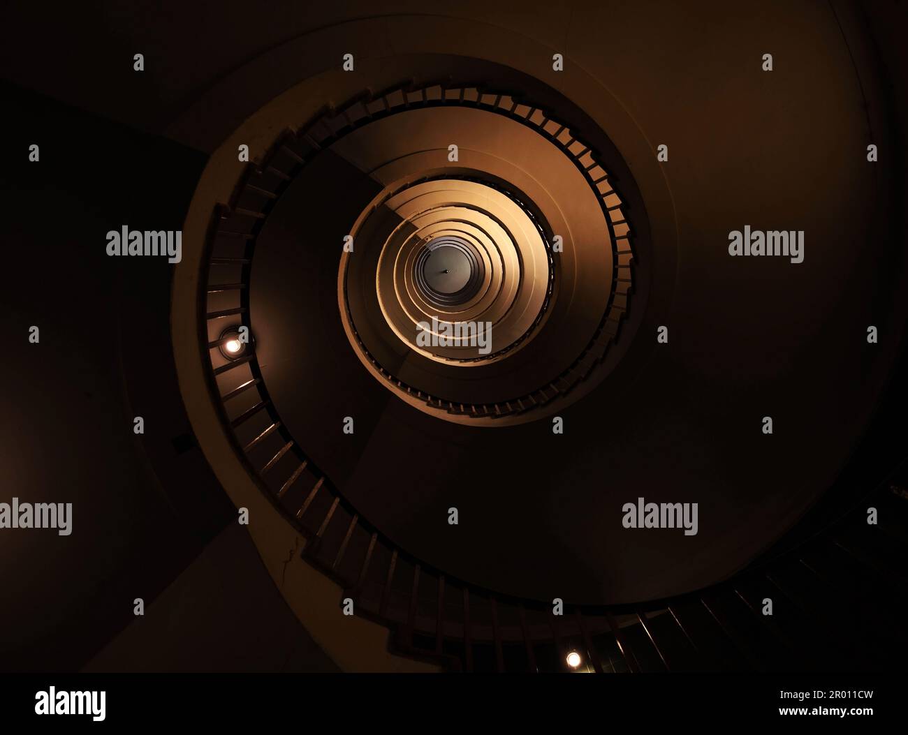 Spiral staircase in a tall multi-floor house, in the form of a "golden ...