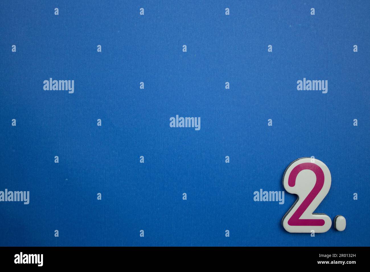 The number 2 in pink and white color, photographed from above, placed ...