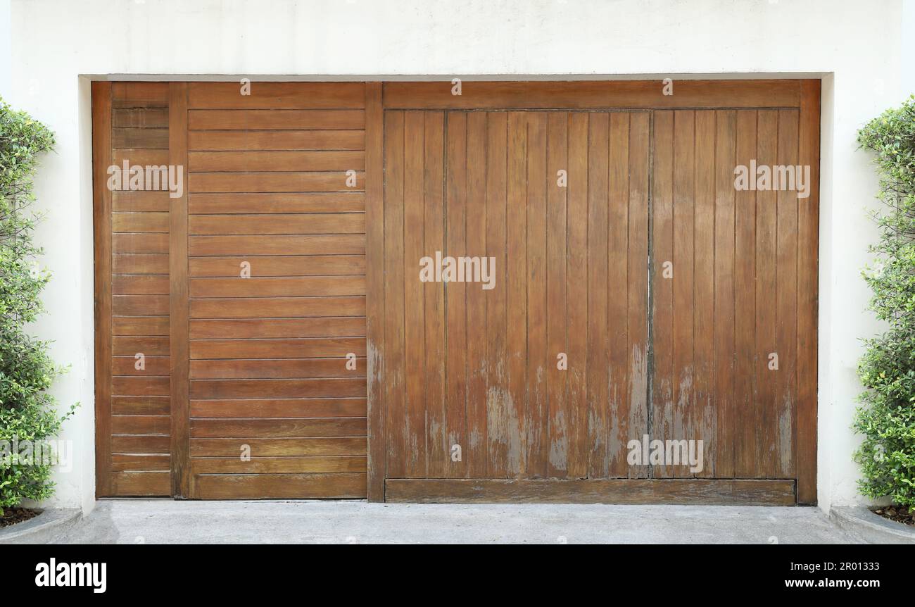 Large wooden gate on cement wall decorated with green tree Stock Photo ...
