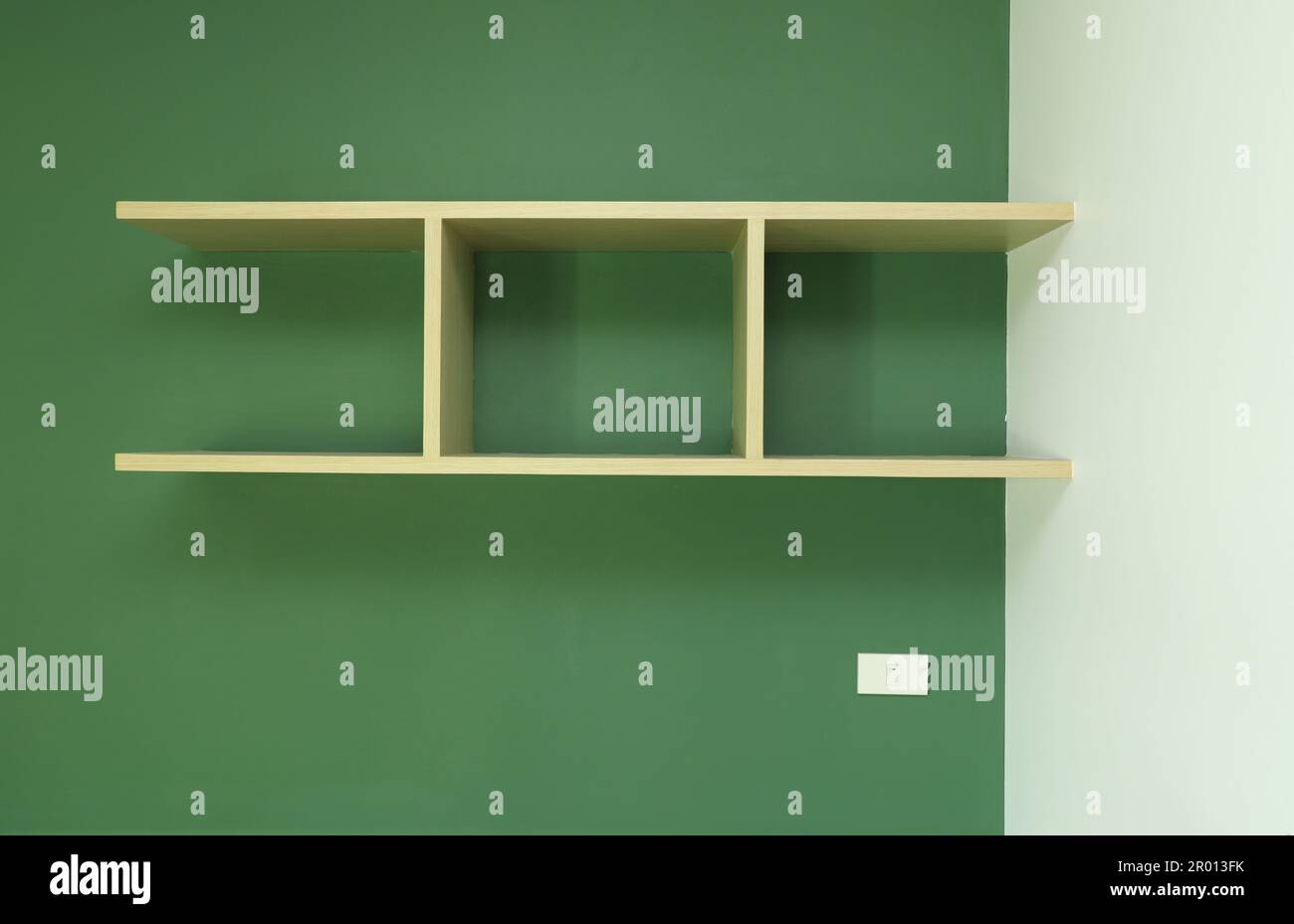 Wooden shelf and white socket installed on green wall Stock Photo - Alamy
