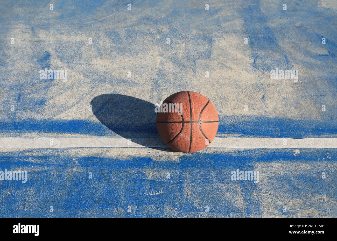 Red ball on outdoor blue basketball court Stock Photo - Alamy