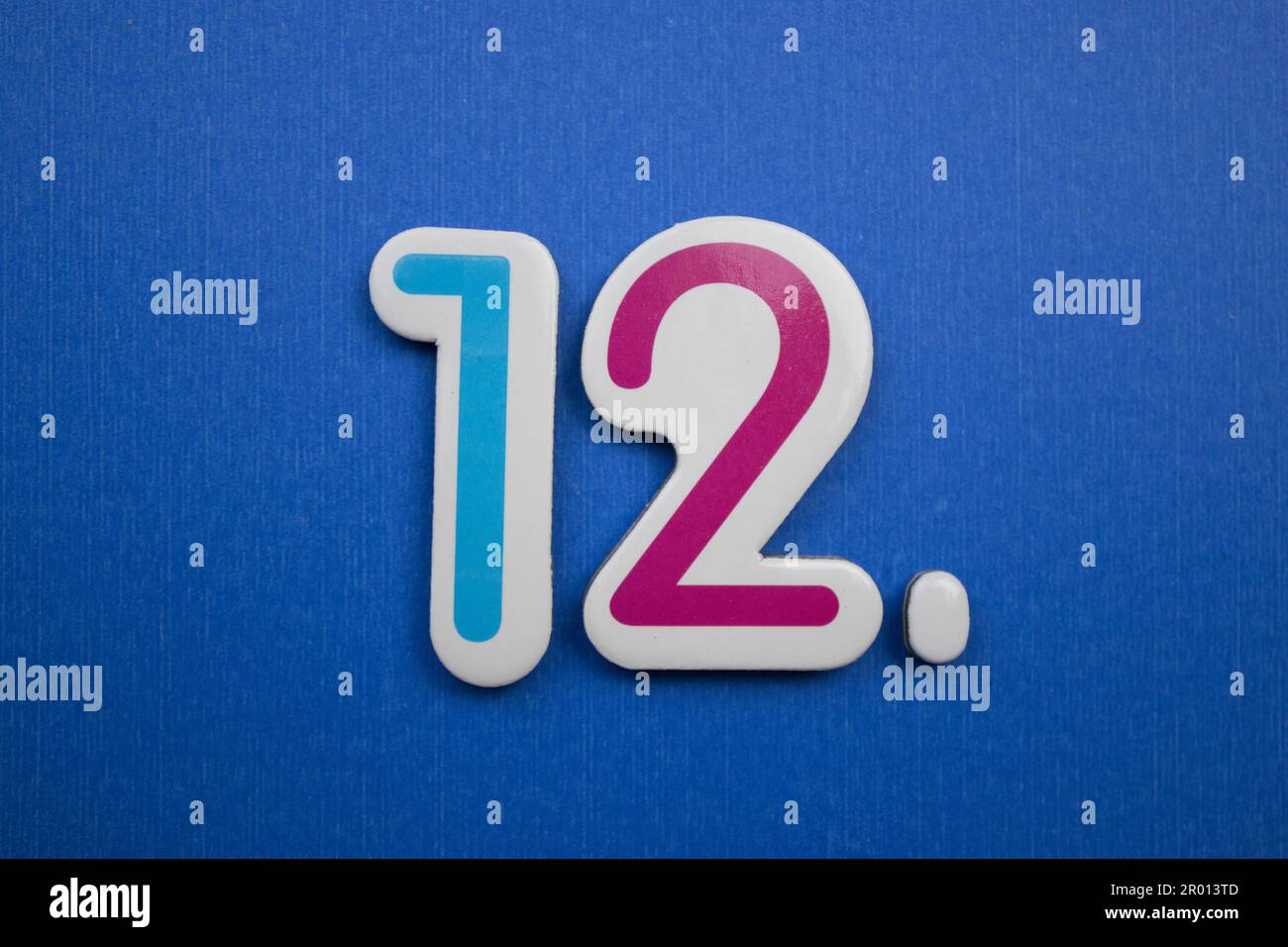 The number 12, placed on a blue background, photographed from above, colored light blue and red ...