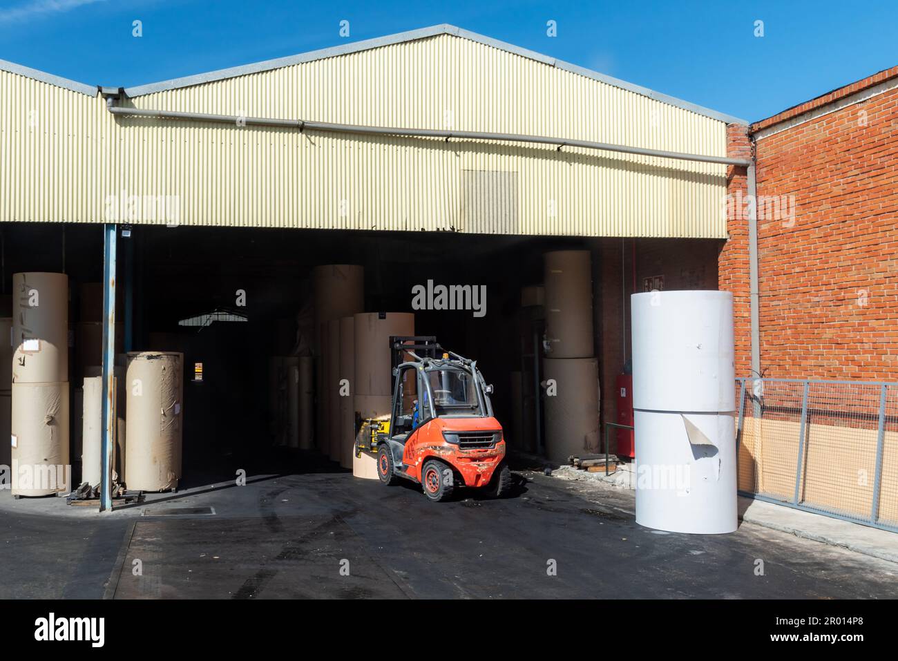 Forklift with clamps to move reels of paper in a warehouse Stock Photo ...