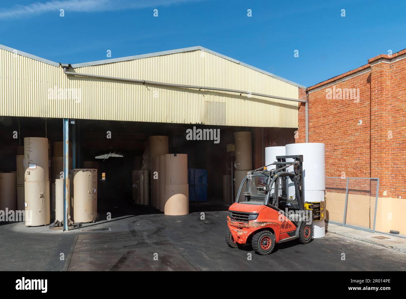 Forklift with clamps to move reels of paper in a warehouse Stock Photo ...