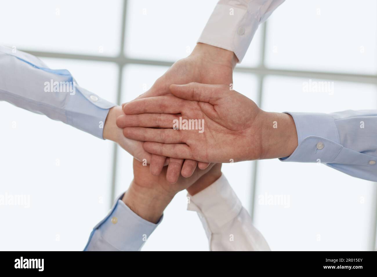 Diverse business team putting their hands together in a huddle of support and motivation Stock ...