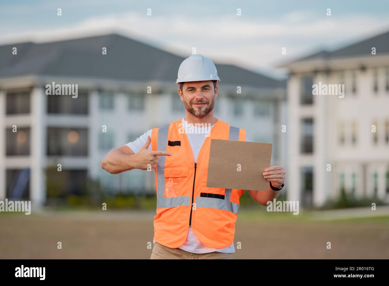Engineer hold paper board for text. Builder showing signboard placard ...