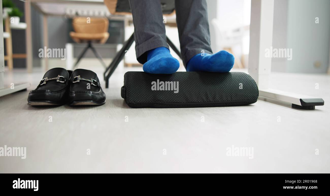 Man Using Footrest To Reduce Back Strain And Feet Fatigue Stock Photo ...