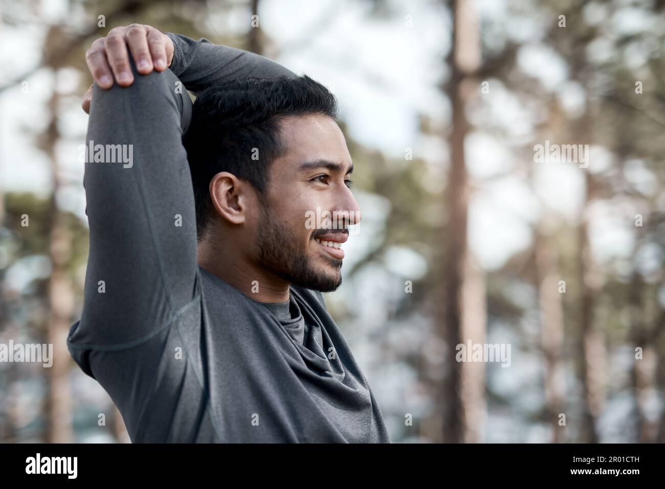 Keeping an eye on my fitness goals. a handsome young man stretching ...