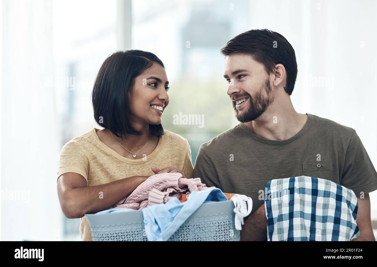 Loads of love and laundry. a young couple doing laundry together at ...
