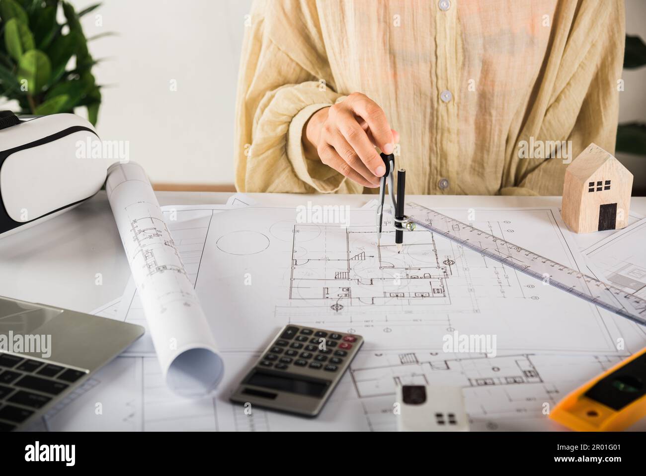 Architect drawing with divider compass on house plan blueprint paper ...