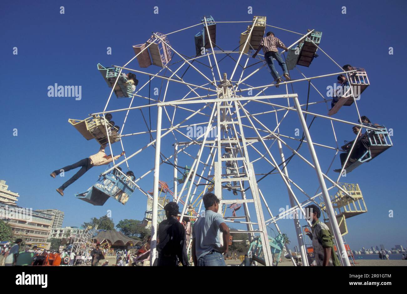 a Ferris Wheel, Jester and artist at the Chowpatty Beach in the city ...