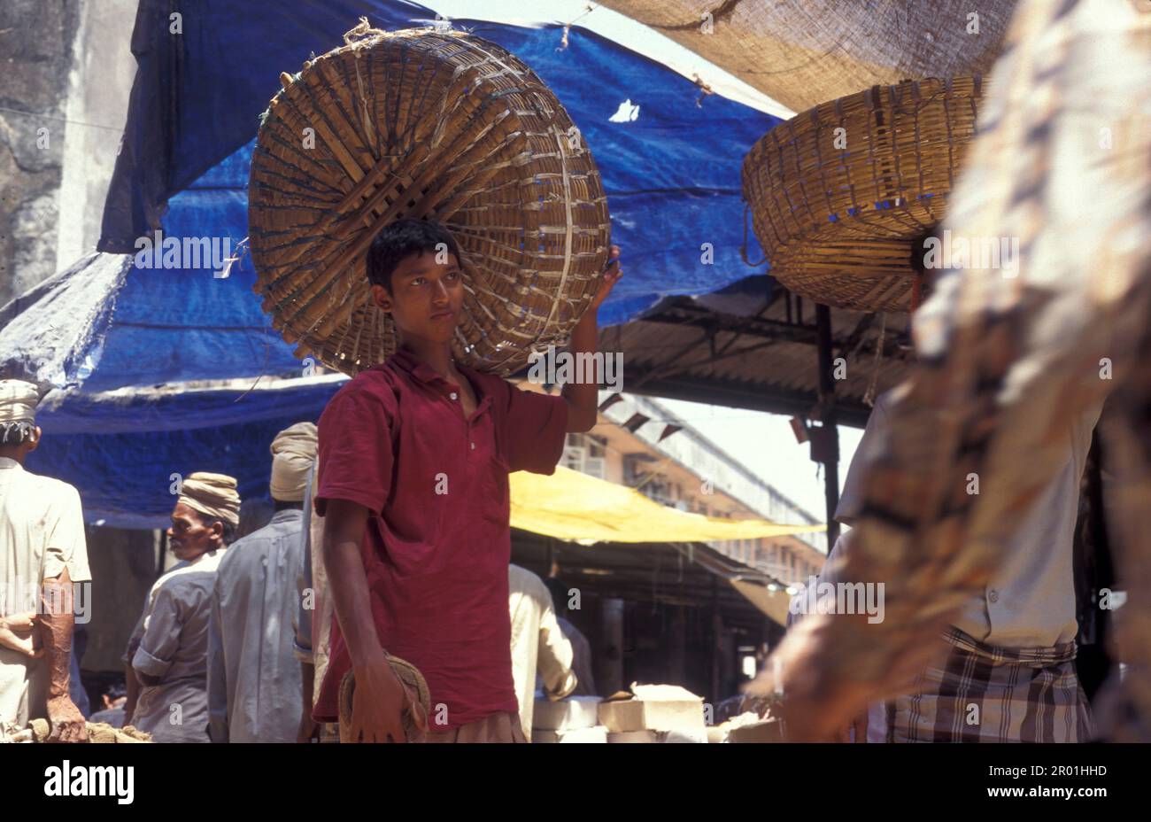 indian carrier at a market street with shops and People in the city ...