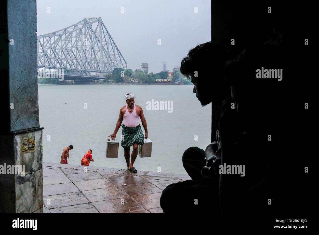 People seen at the ghat of the holy river Ganga with the background of ...