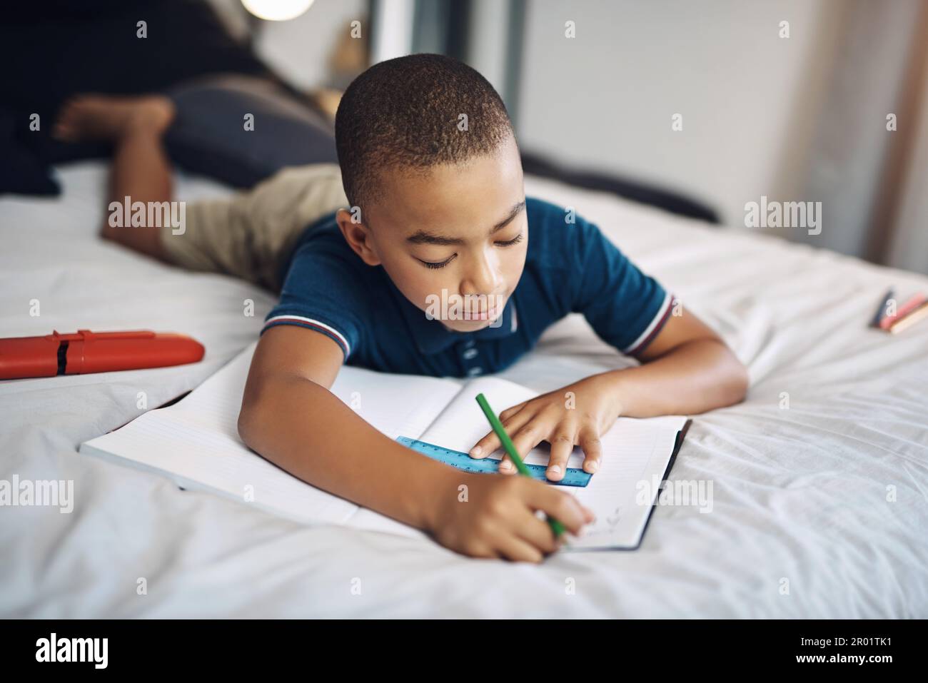 Doing homework on my favourite lesson. a young boy using colouring ...