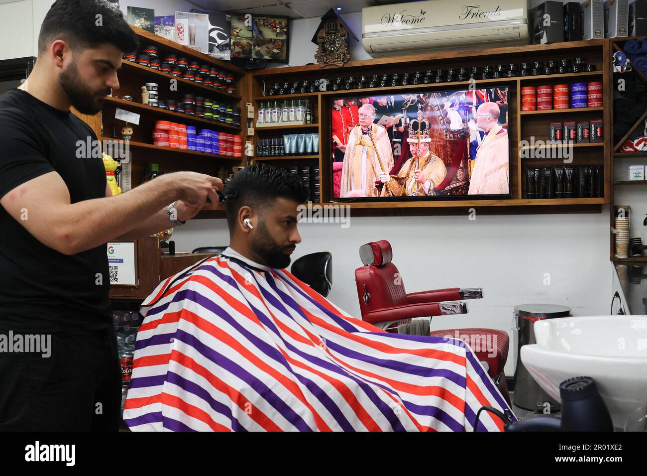 London, UK. May 6, 2023. A TV screen shows the Coronation of King Charles III in Dylan’s Barbers ...