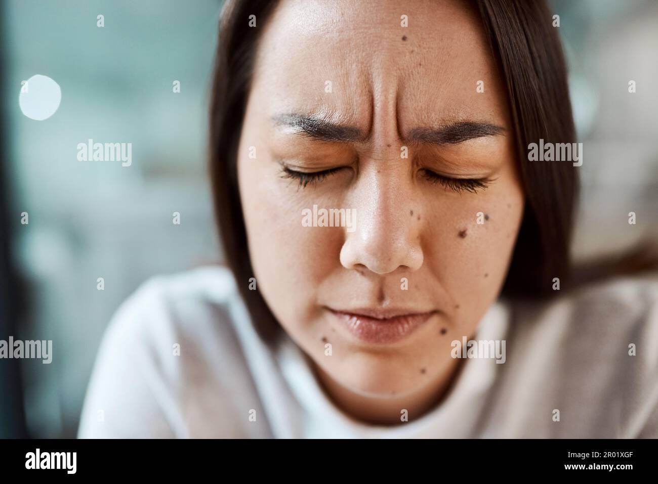 Feeling a mix of emotions building up. a young woman closing her eyes ...