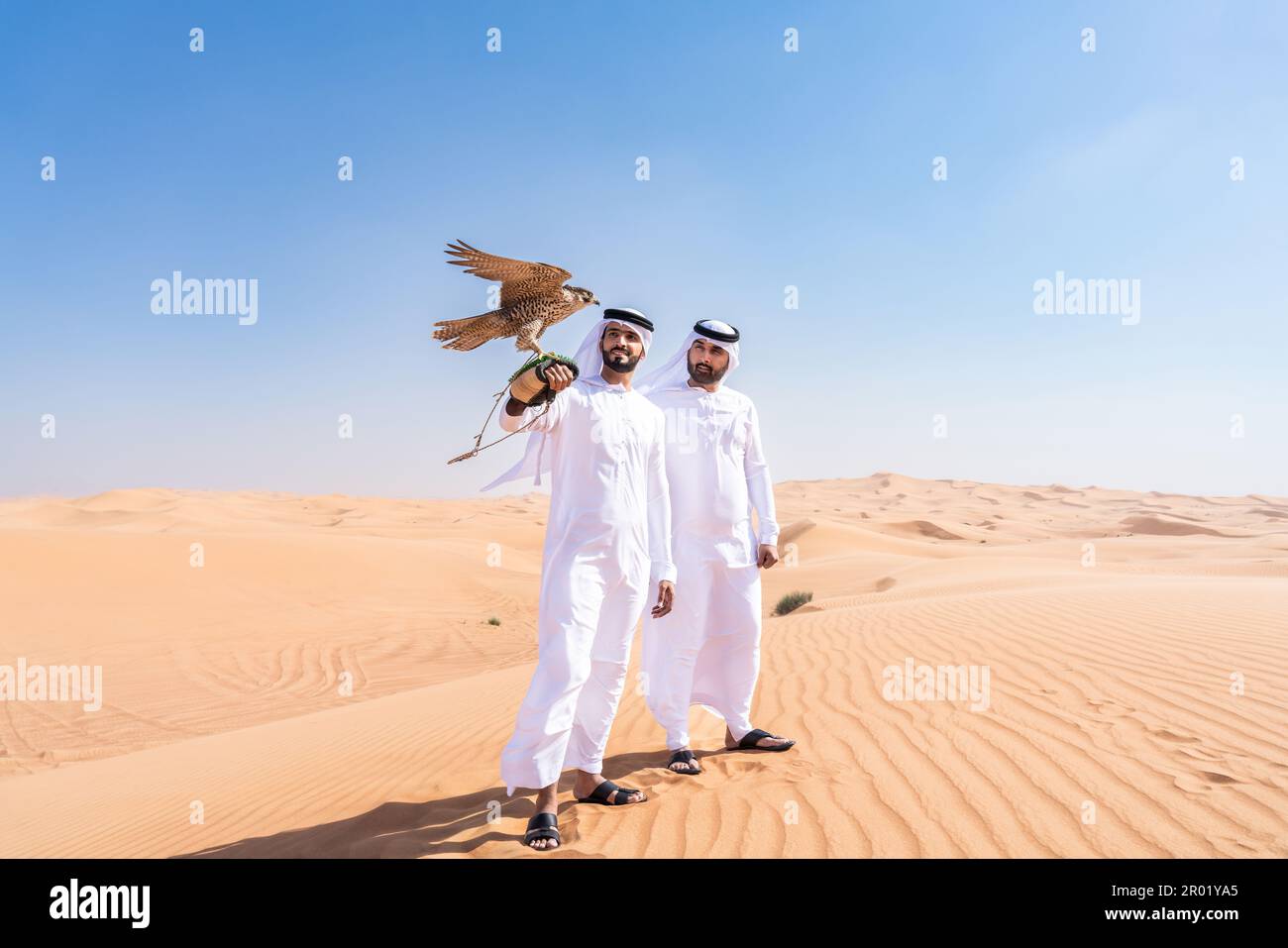 Two middle-eastern men wearing traditional emirati arab kandura bonding ...
