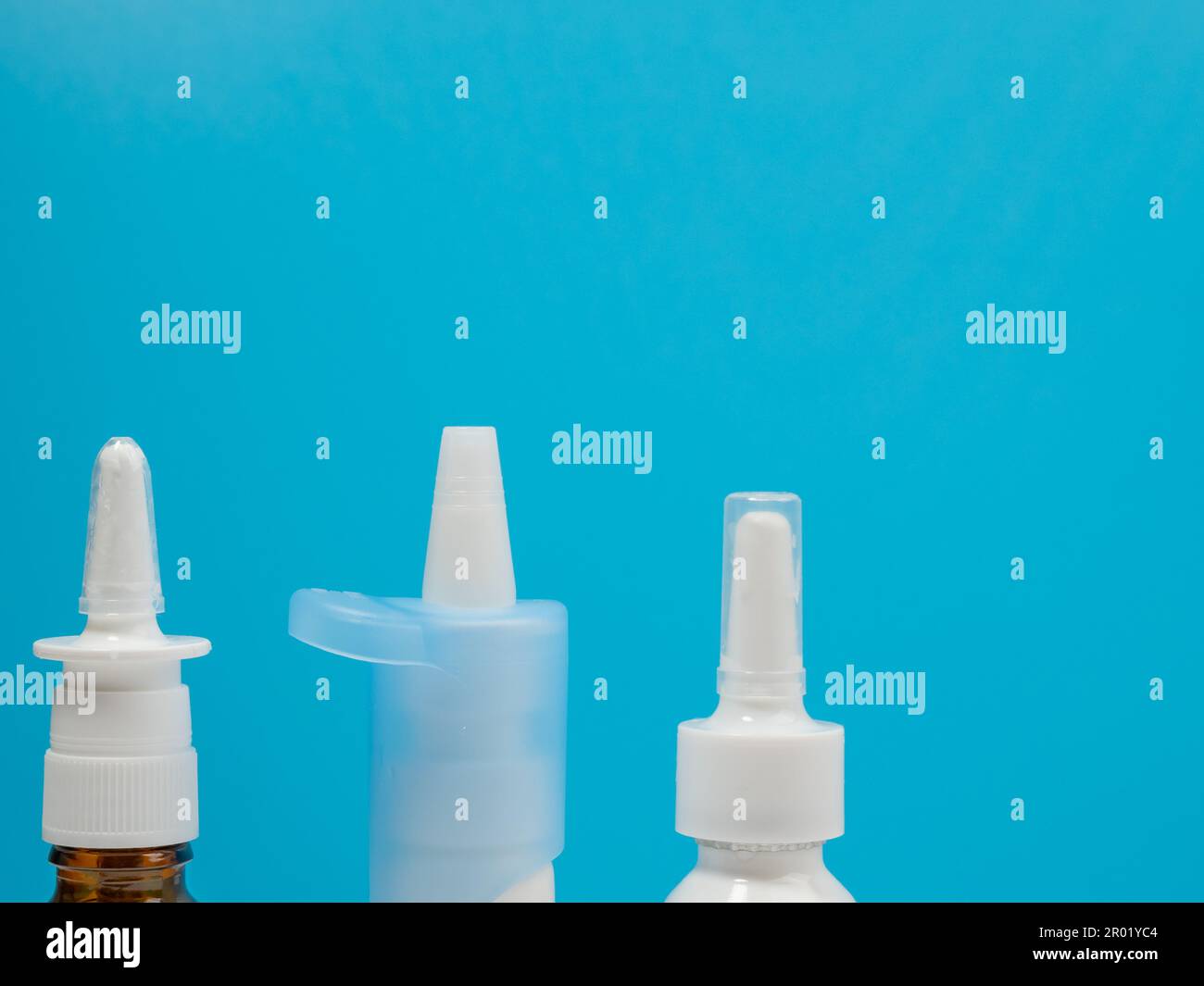 Nasal spray bottles on a blue background, treating a cold with a nasal ...
