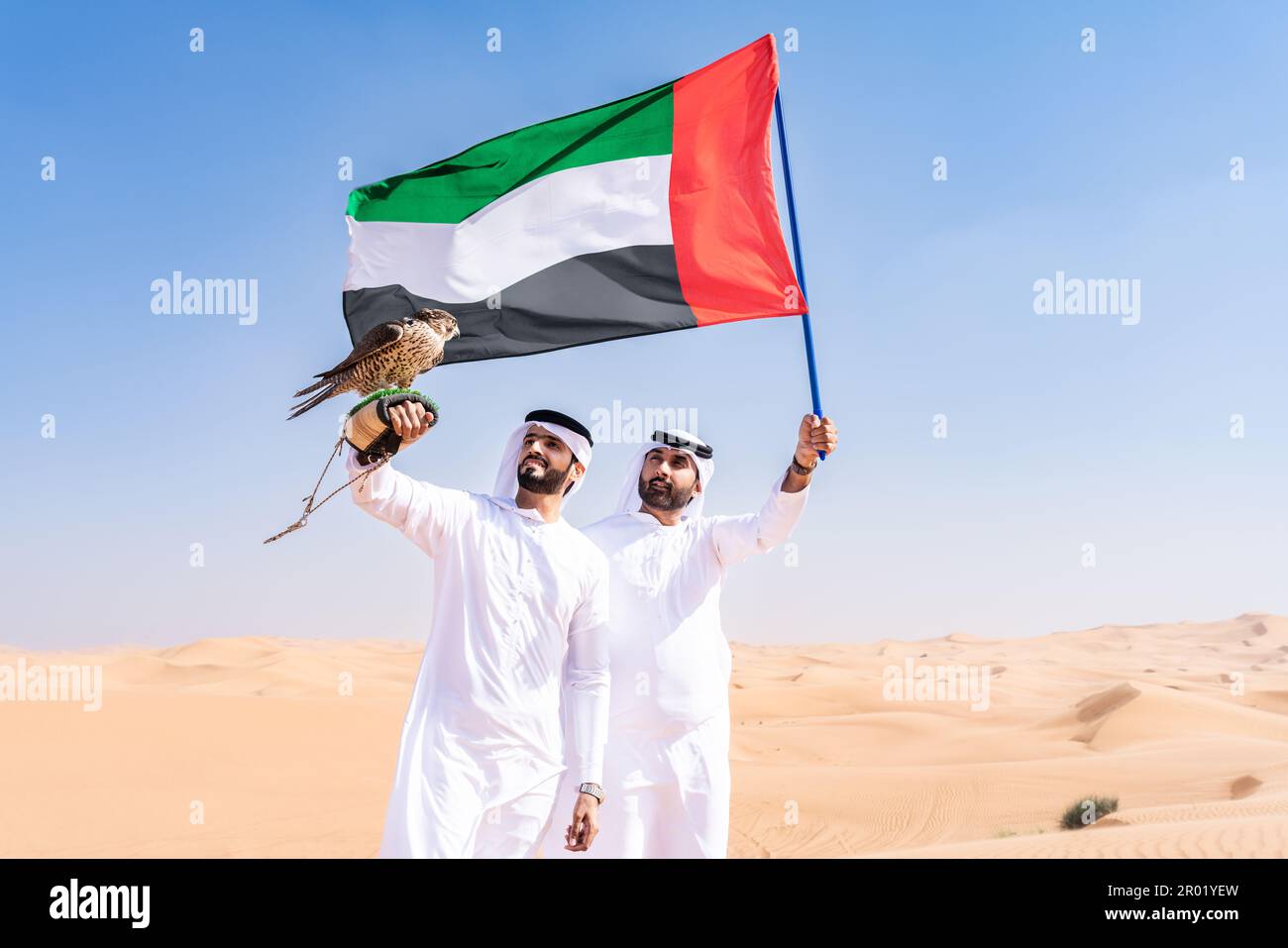 Two middle-eastern men wearing traditional emirati arab kandura bonding ...