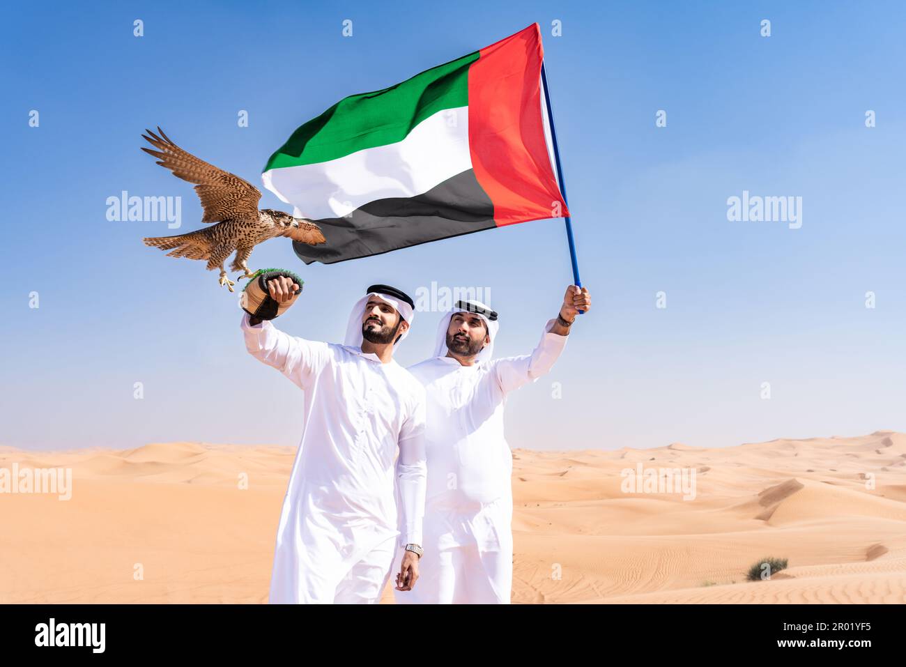 Two middle-eastern men wearing traditional emirati arab kandura bonding ...