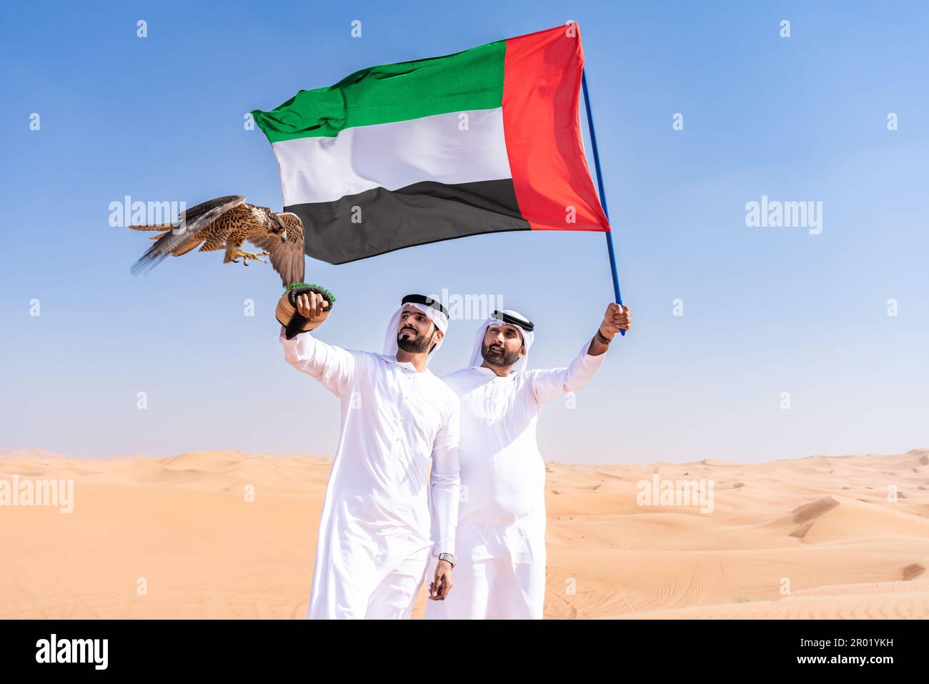 Two middle-eastern men wearing traditional emirati arab kandura bonding ...