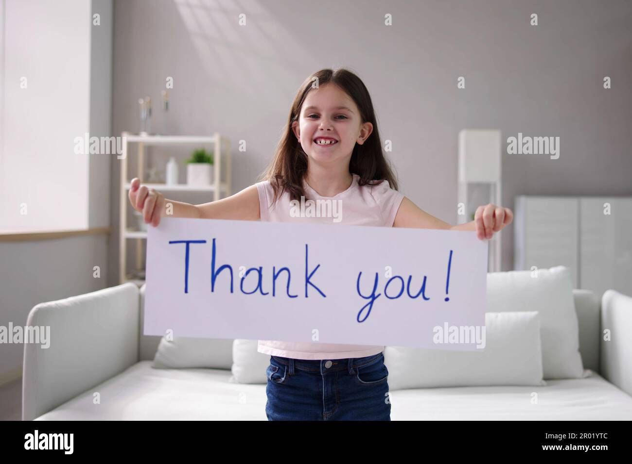 Close-up Of A Smiling Girl Holding Thank You Sign Against White ...