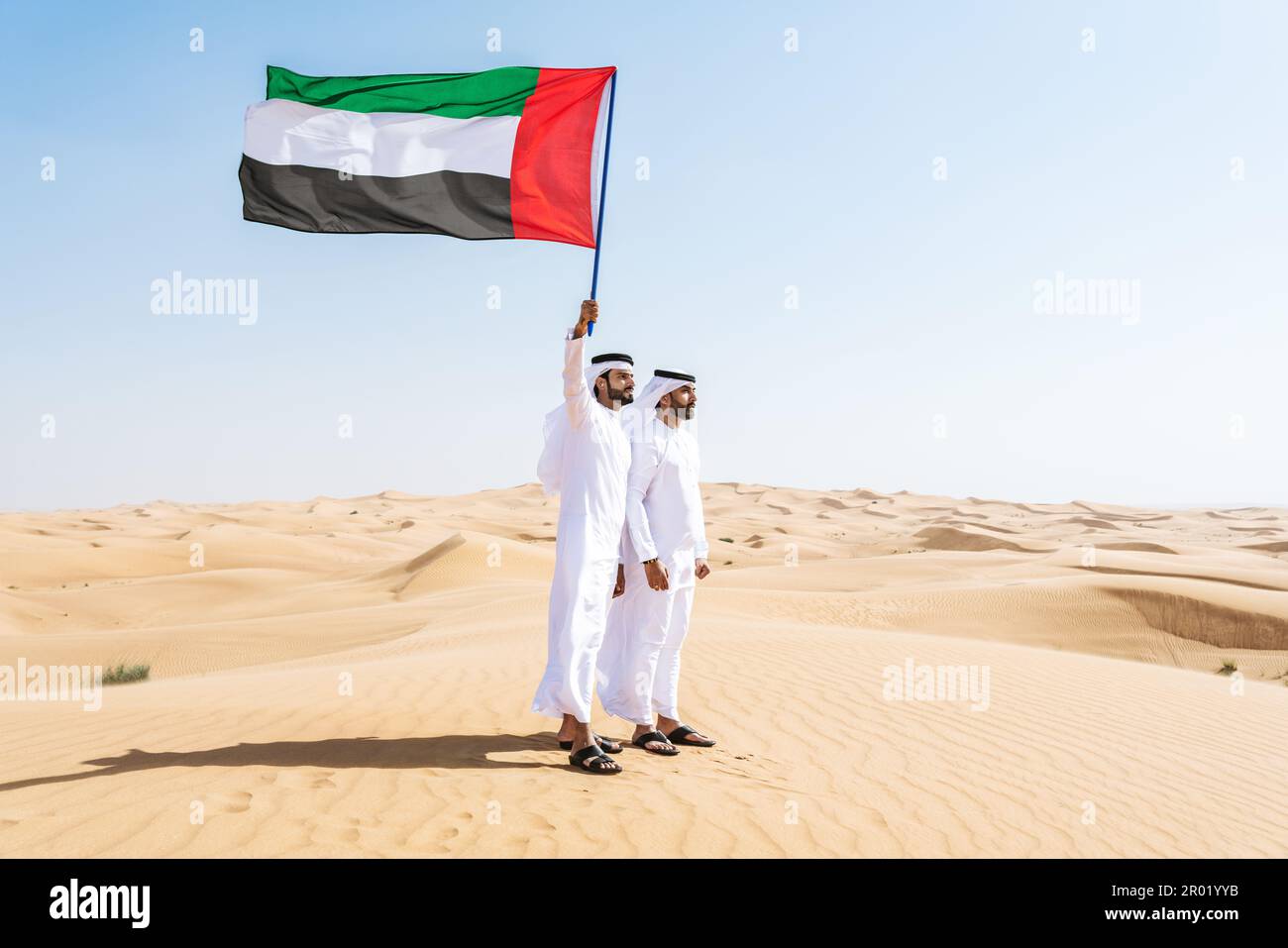 Two middle-eastern men wearing traditional emirati arab kandura bonding ...