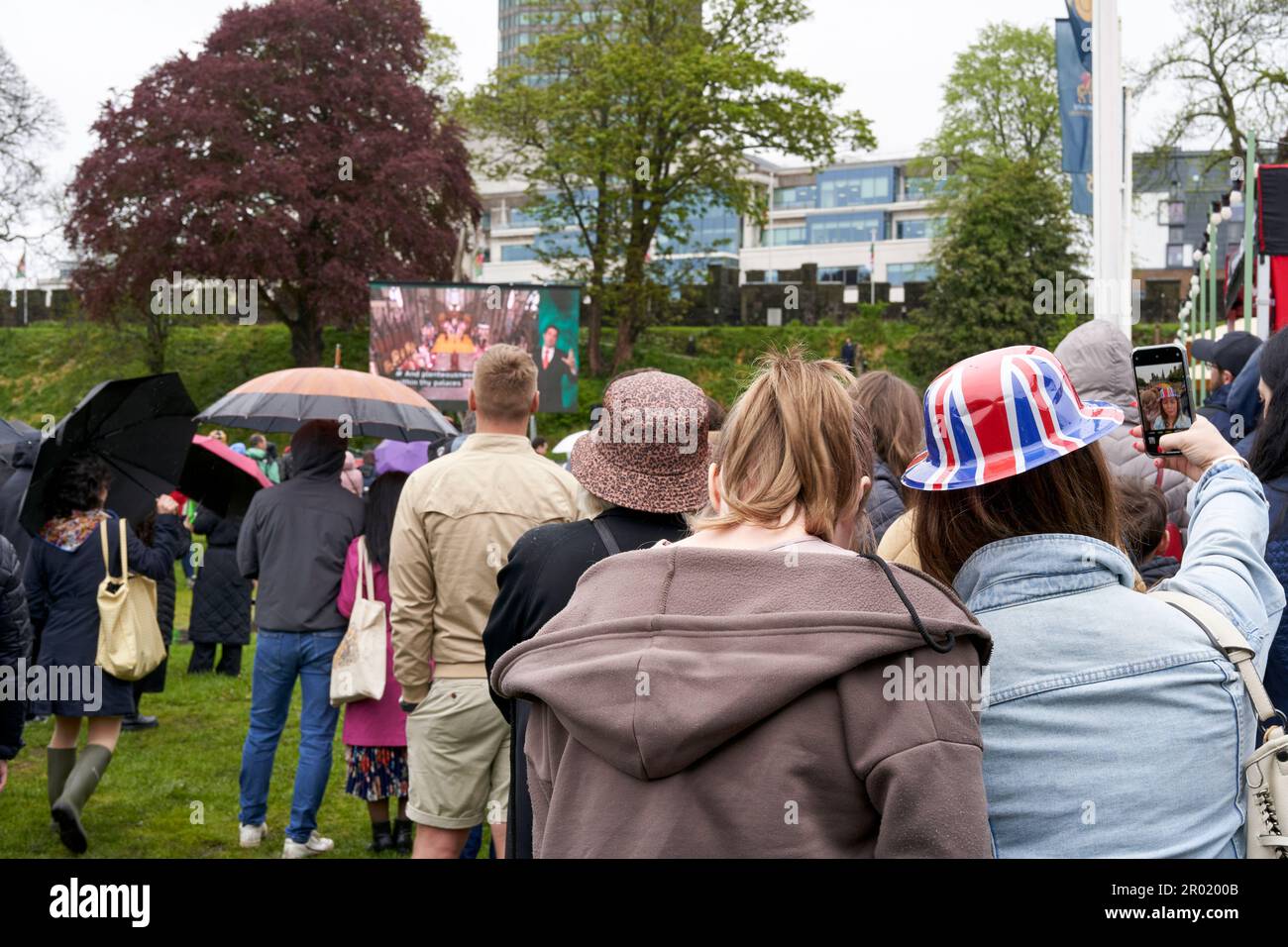 Crowd watching the coronation of Charles III on a big screen in the ...