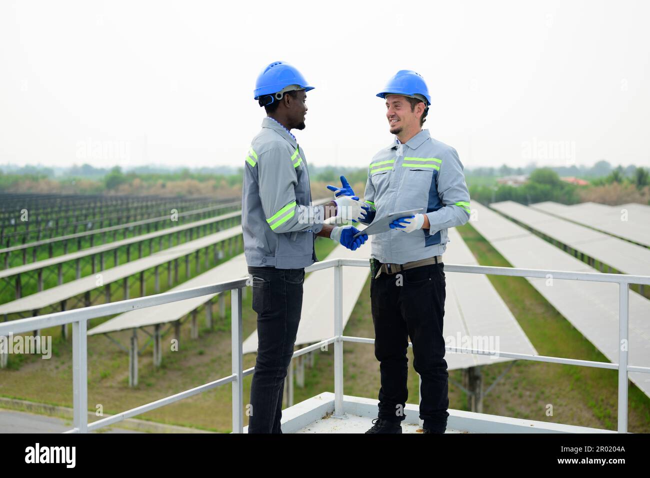 Happy maintenance engineers checking and maintaining solar panels Stock ...