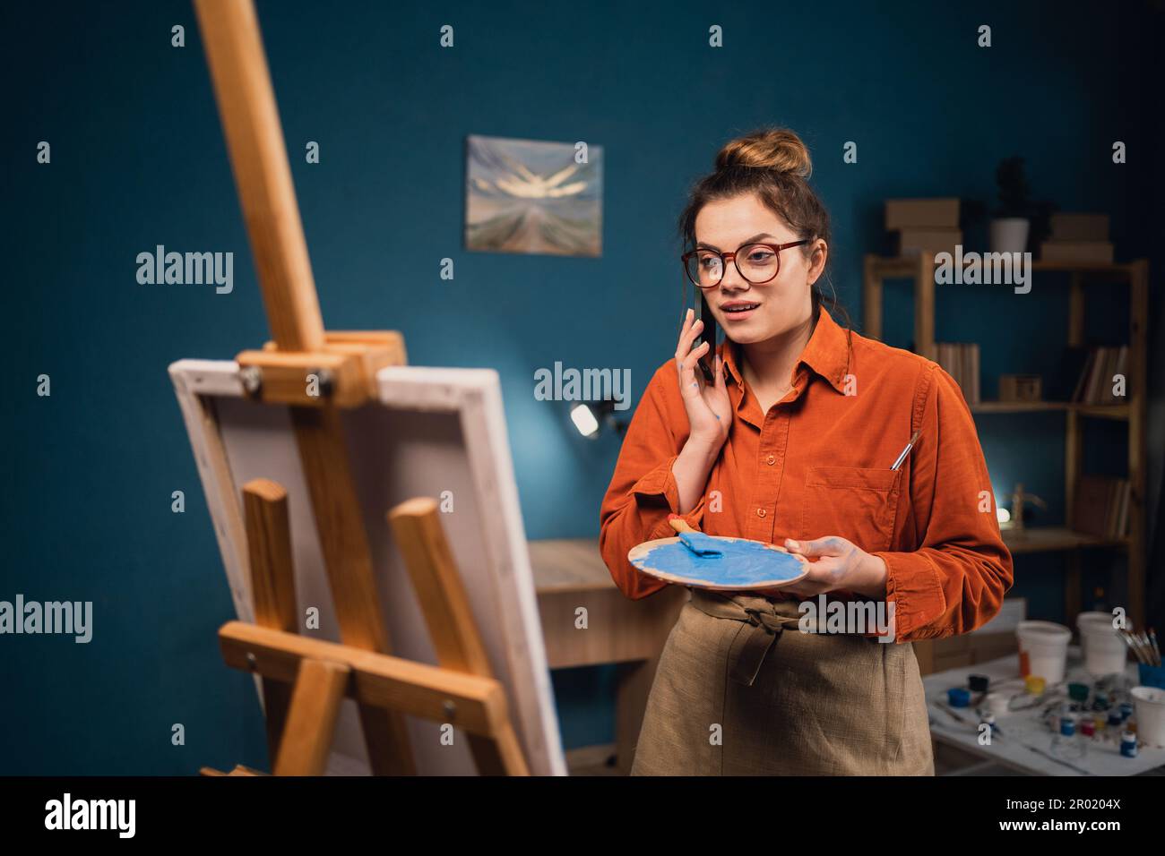 inspirational concentrated latino woman in apron draws pictures with ...