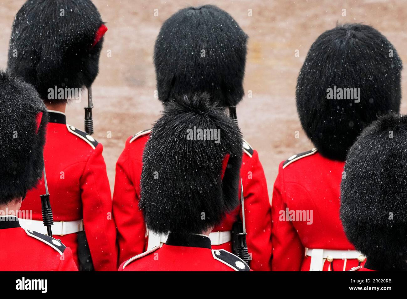 Raindrops cover Bearskin hats of the King's Guards as they wait outside ...