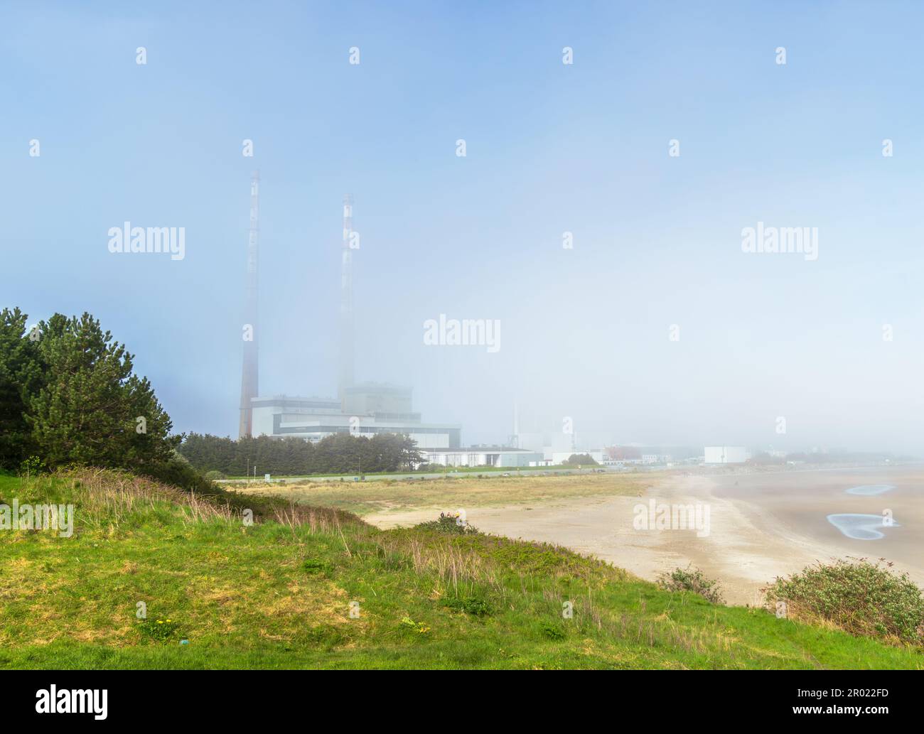Poolbeg Chimneys appear out of the fog from Irishtown Stock Photo - Alamy