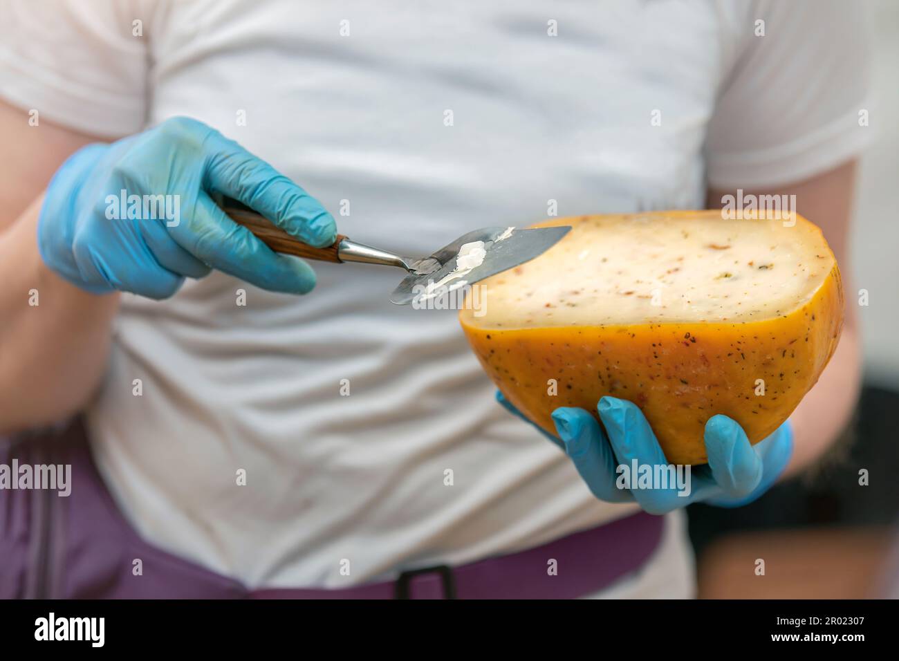 A man gives a cheese tasting to his customer. Cheese tasting. Cheese is ...