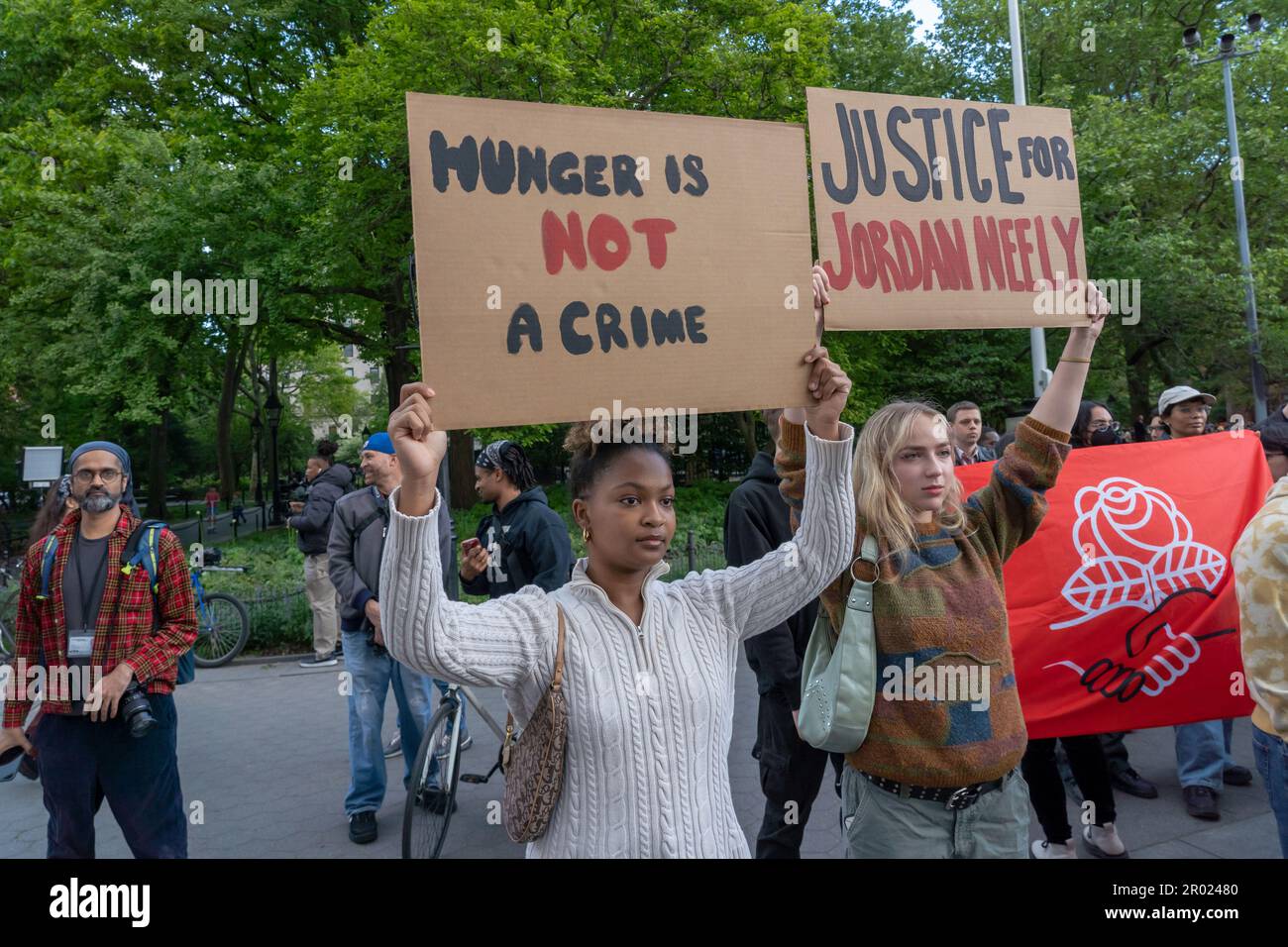 Women hold "HUNGER IS NOT A CRIME" and "JUSTICE FOR JORDAN NEELY" signs ...